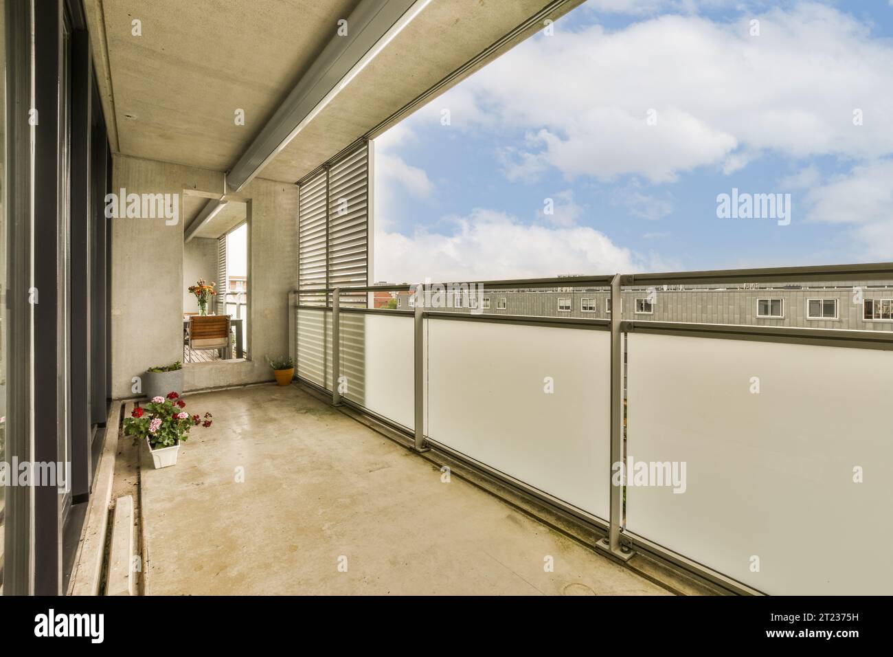 a balcony with white walls and grey metal railings on the right side ...