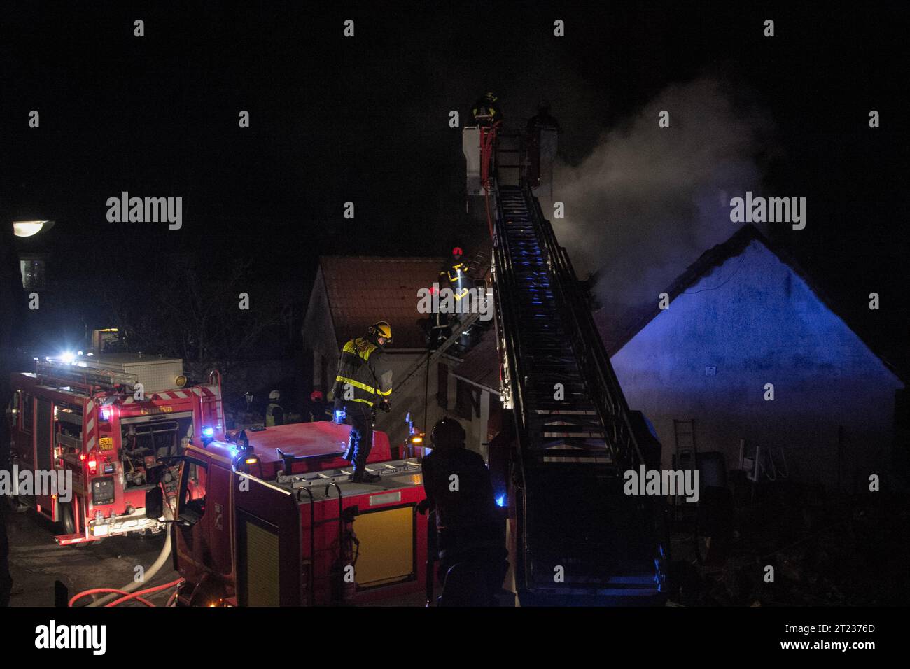 Firemen fight a house fire in a village in France at night with two ...