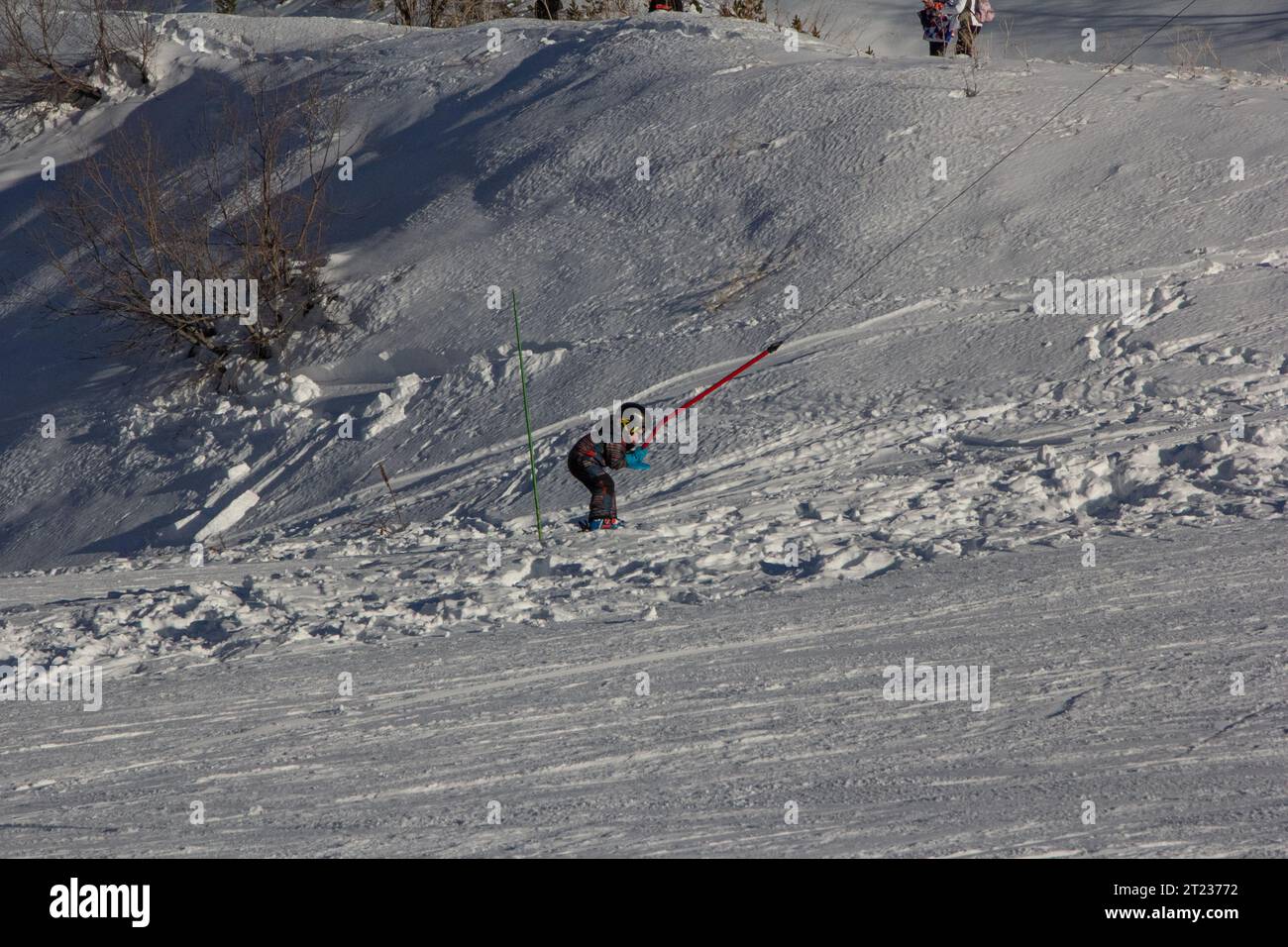 A small child hasn't quite got the hang of the ski button lift in ...