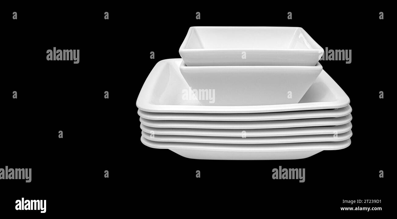 A stack of square white plates isolated on black background with copy ...