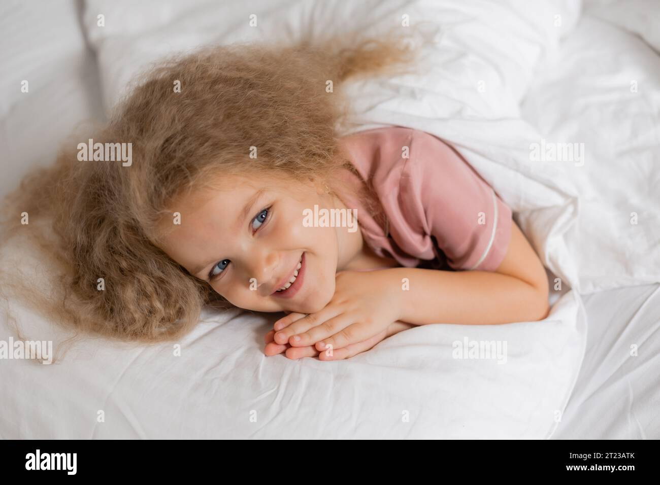 Cute curly-haired girl sleeping in bed covered with a blanket Stock ...