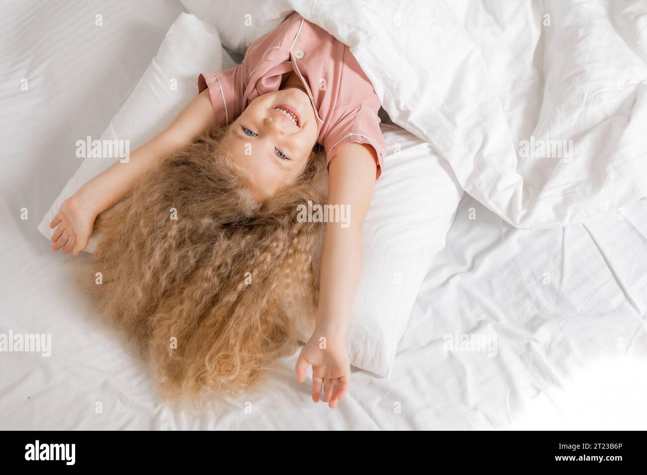Cute curly-haired girl sleeping in bed covered with a blanket Stock ...