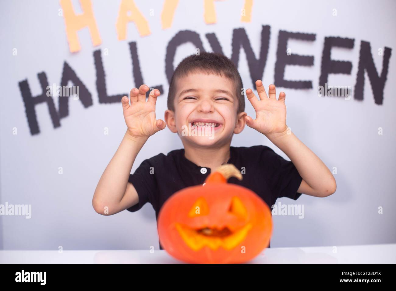 An adorable young boy in front of a spooky Halloween-themed background ...