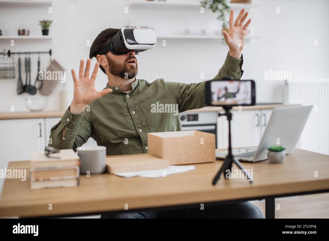 Man filming video on smartphone while reviewing VR headset Stock Photo ...