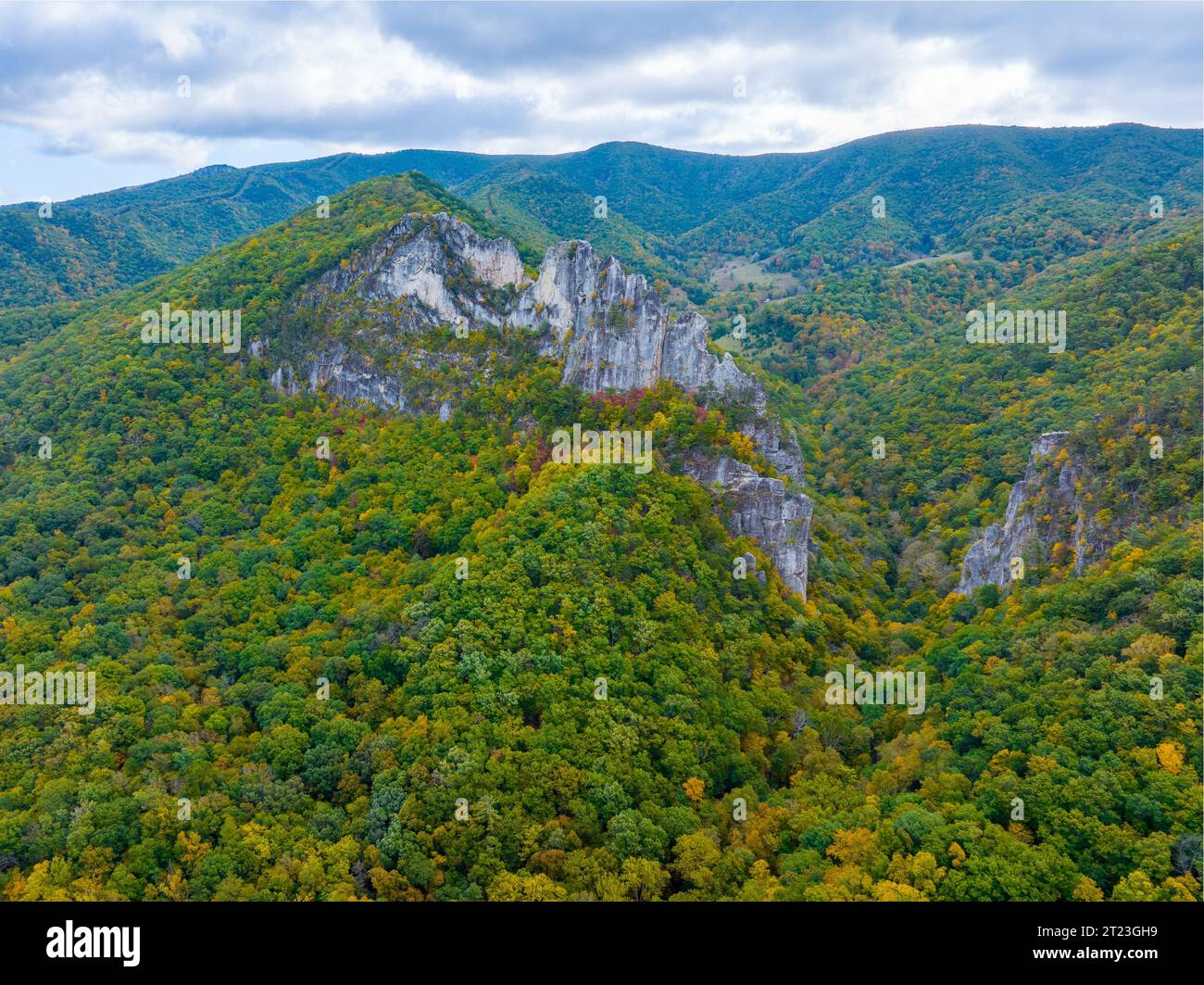 An aerial view of the Seneca Rocks with lush vegetation and clouds ...