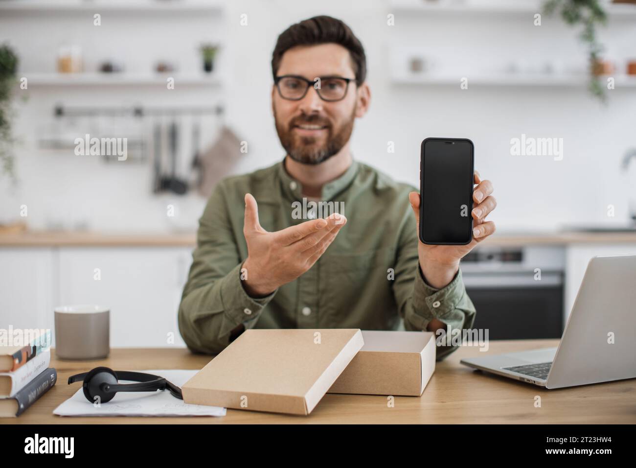 Male influencer unpacking new smartphone and live streaming Stock Photo ...