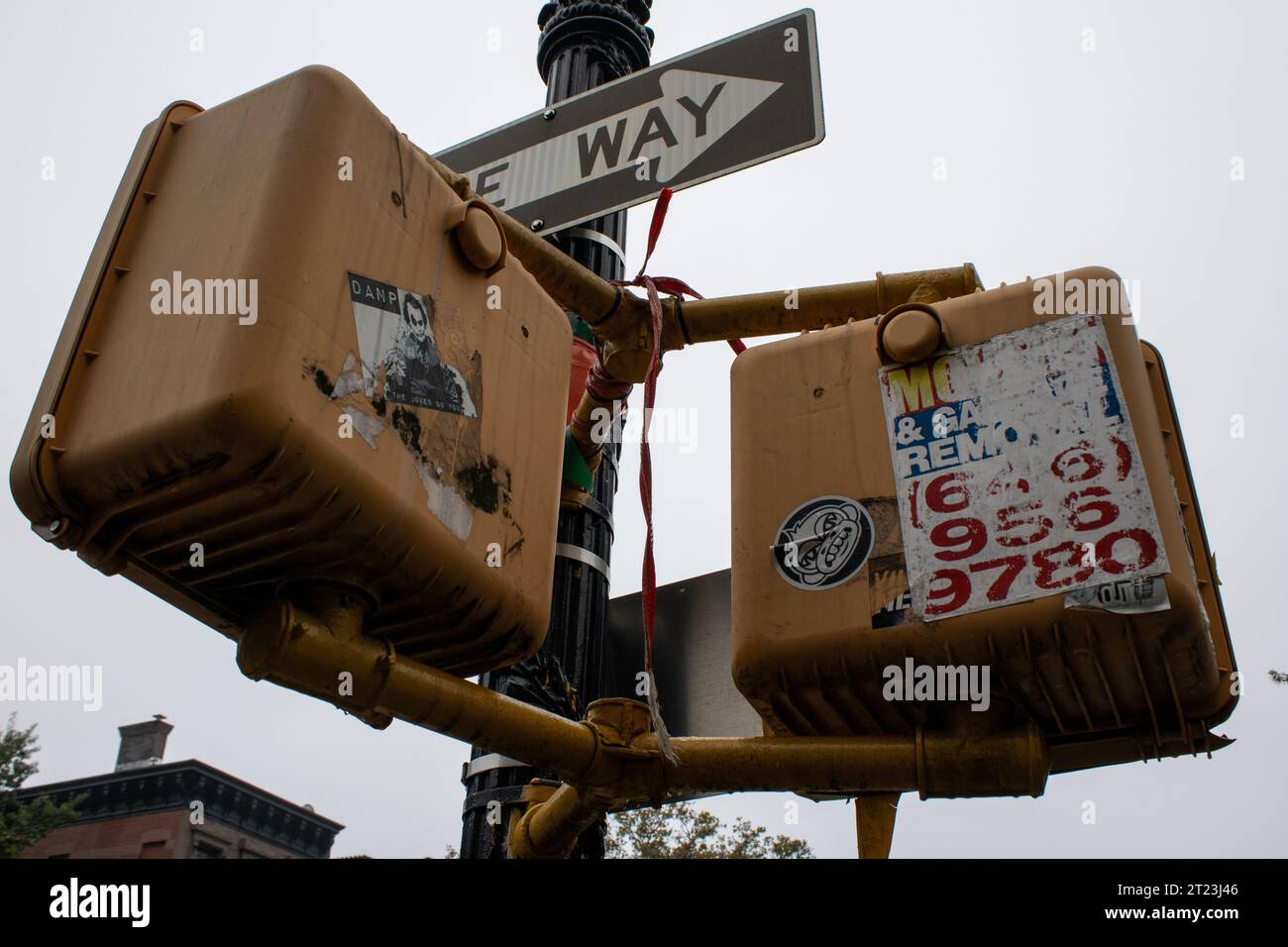 A traffic light with multiple colorful stickers adorning the front of ...