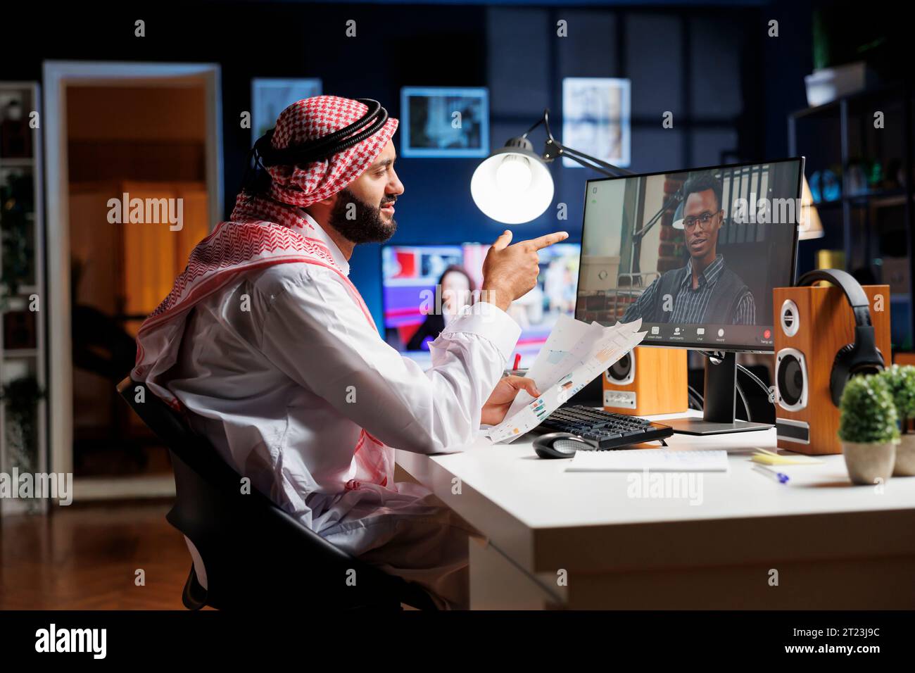 Picture of a Muslim man handling paperwork while chatting with his ...
