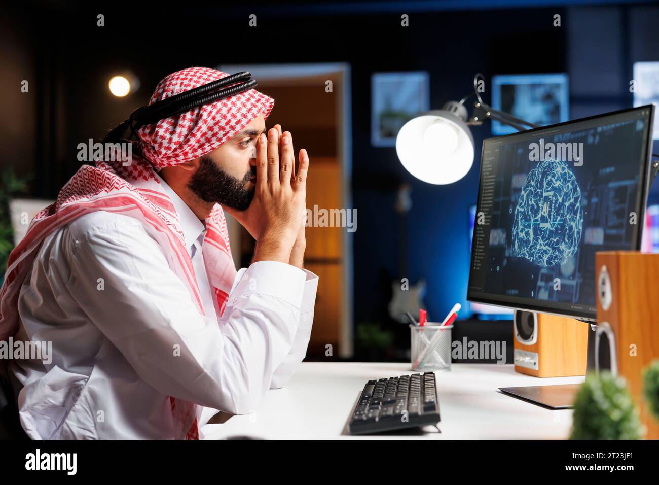 Arab man at desk uses advanced technology to develop secure software ...
