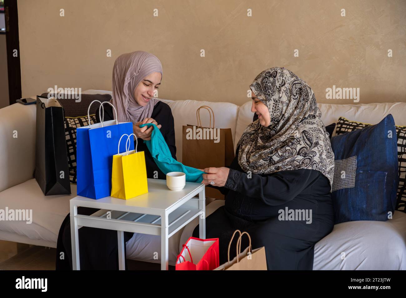 Arabic woman gifting her mother and showing the new clothes after ...