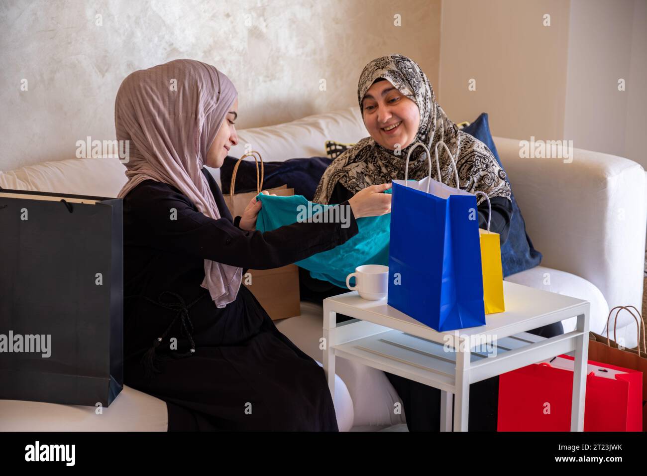 Arabic woman gifting her mother and showing the new clothes after ...