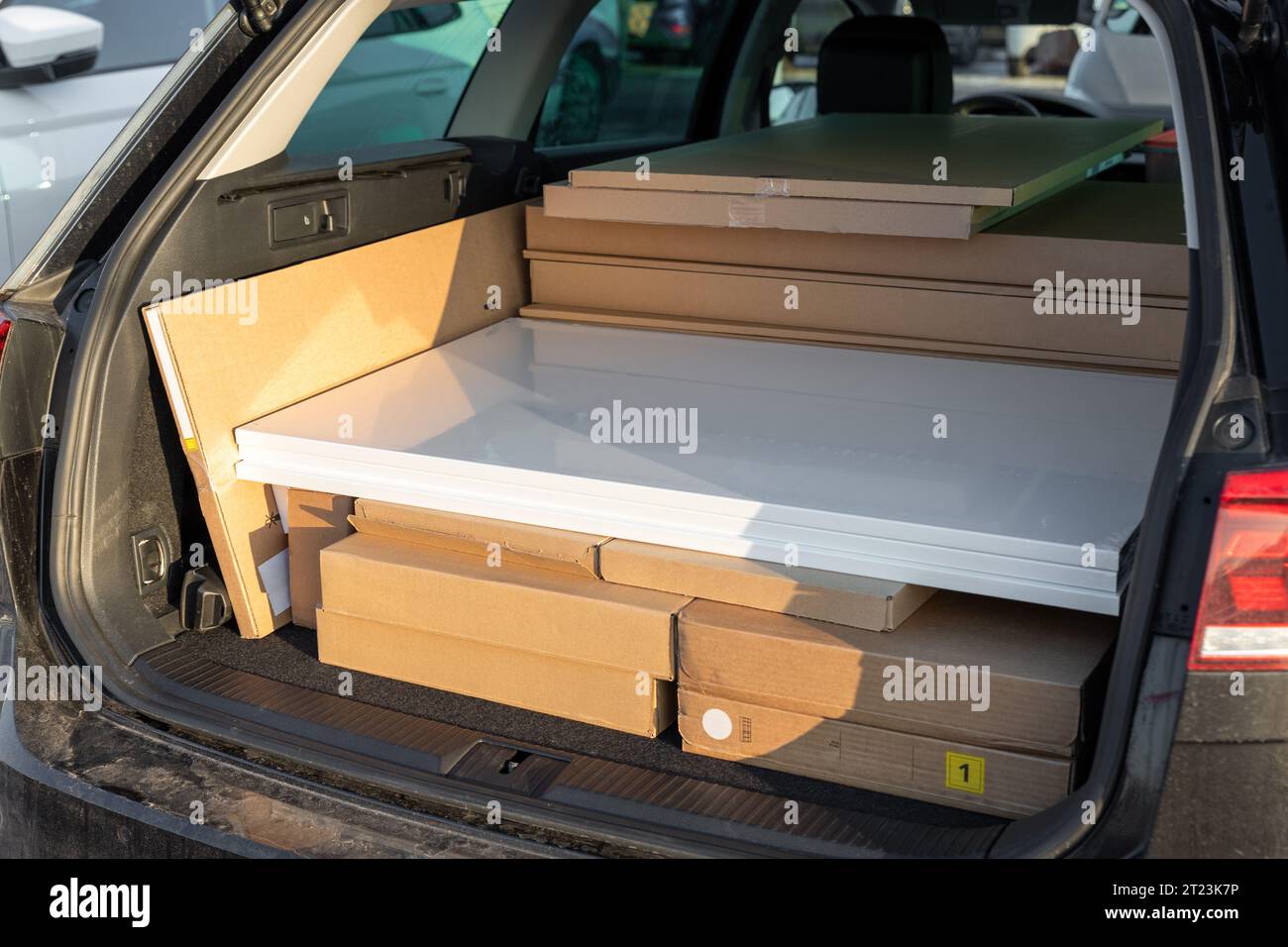 Modern black car wagon with open boot trunk back door fully loaded with ...