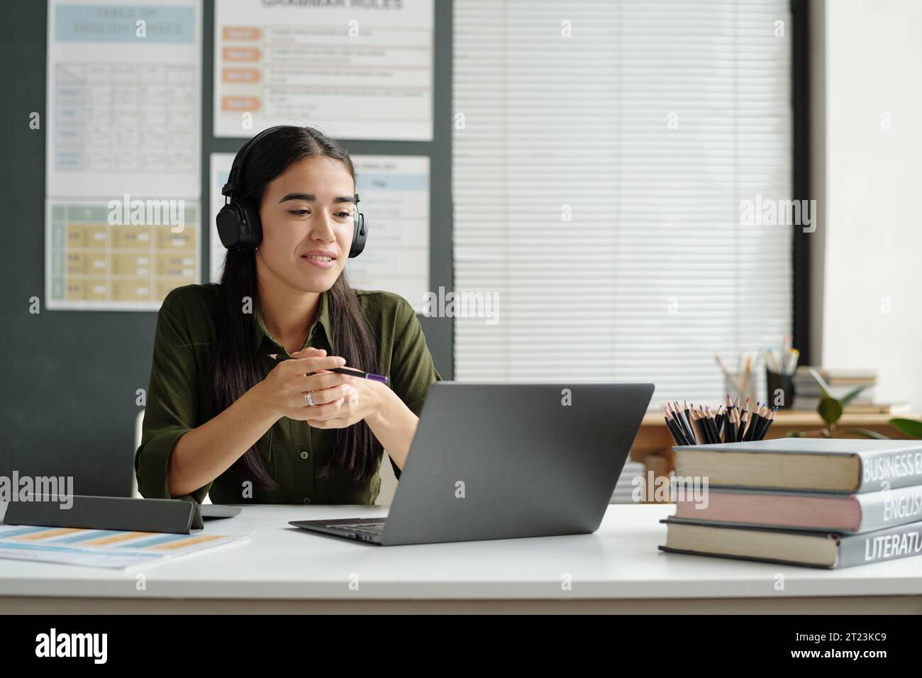 Young confident professional speaking to online learner on laptop ...