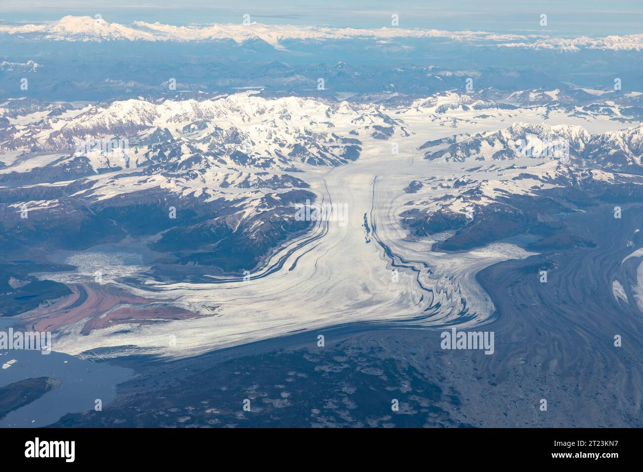 Aerial view of a large glacier field flowing down the valley of a ...