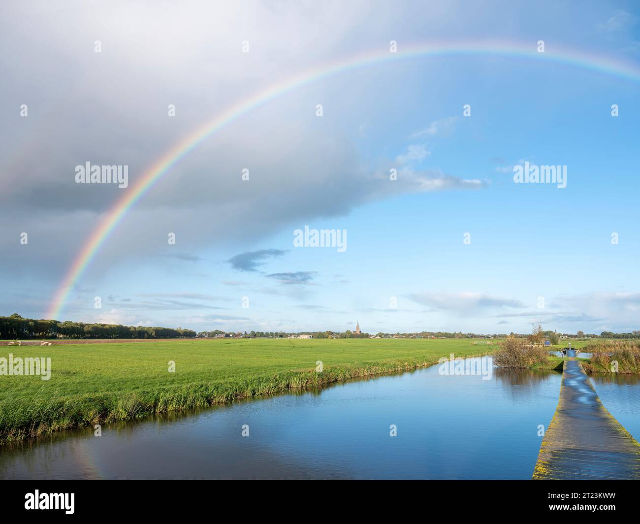 canal between dutch meadows in holland near utrecht with rainbow in ...
