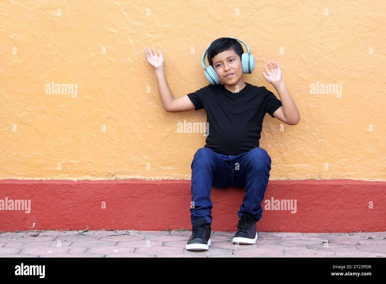 Brown Latino 9 year old boy with anti noise headphones for children ...