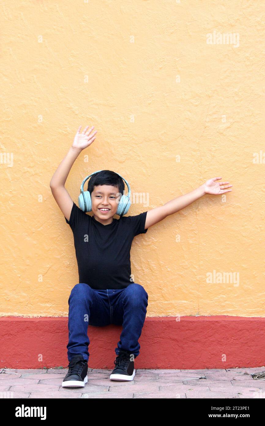 Brown Latino 9 year old boy with anti noise headphones for children ...