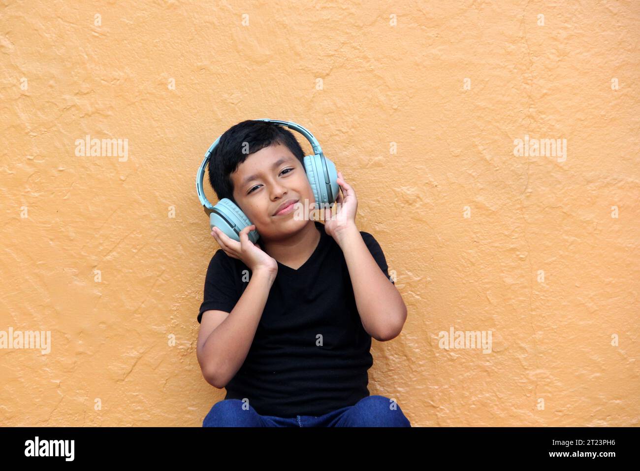 Brown Latino 9 year old boy with anti noise headphones for children ...