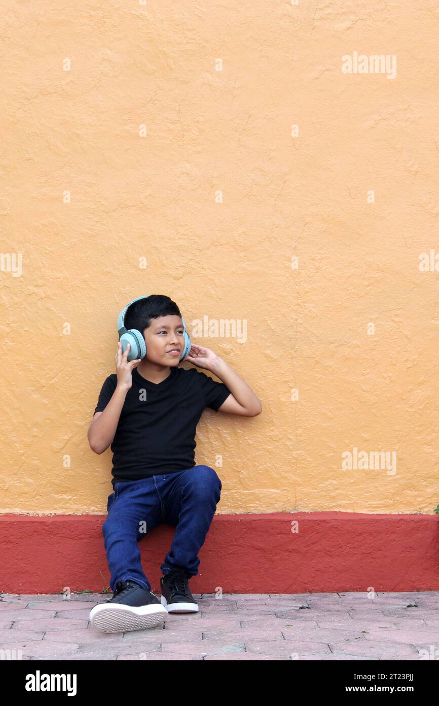 Brown Latino 9 year old boy with anti noise headphones for children ...