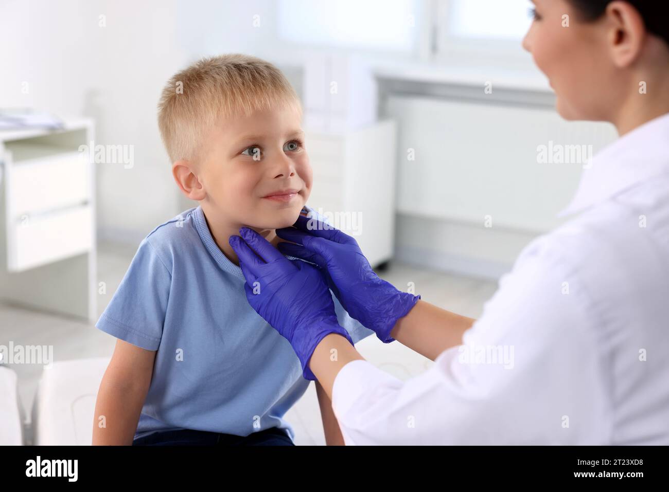 Endocrinologist examining boy's thyroid gland at hospital, closeup ...