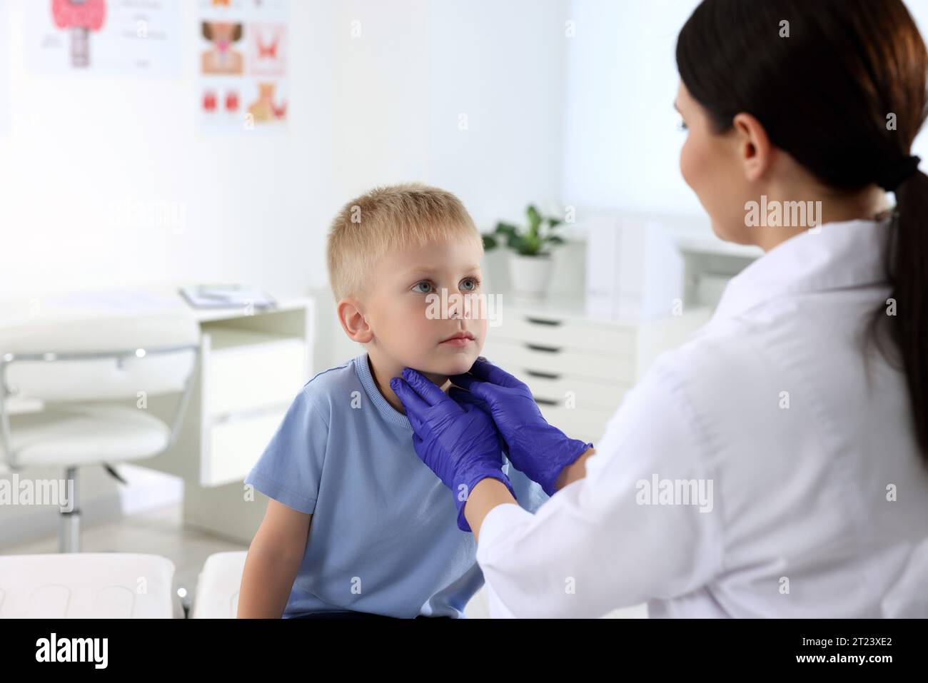 Endocrinologist examining boy's thyroid gland at hospital Stock Photo ...