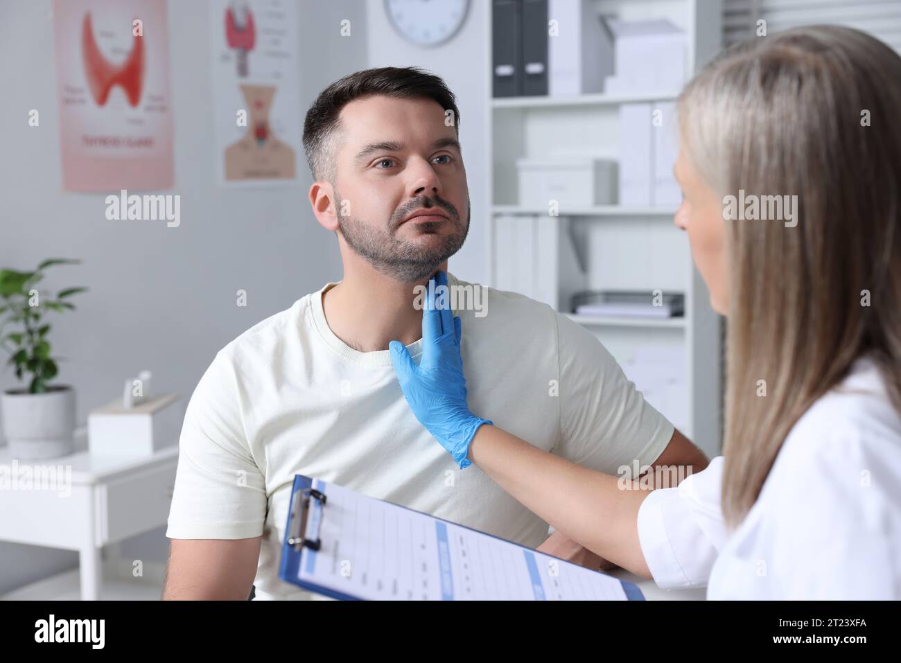 Endocrinologist examining thyroid gland of patient at hospital Stock ...