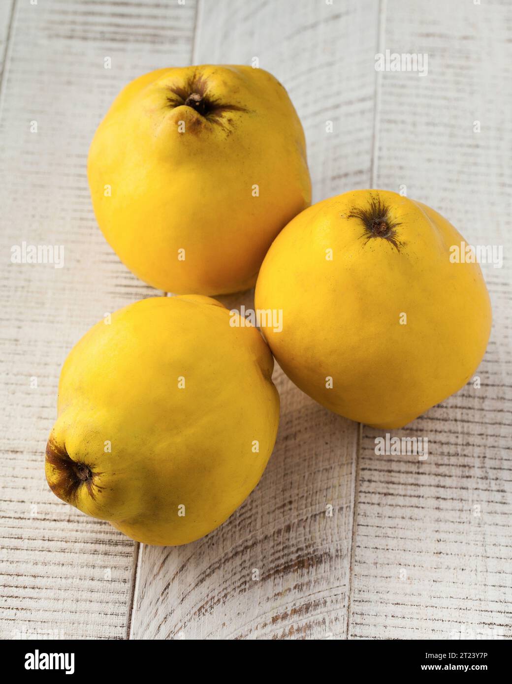 Fruits of juicy ripe quince on a white wooden background. Healthy ...