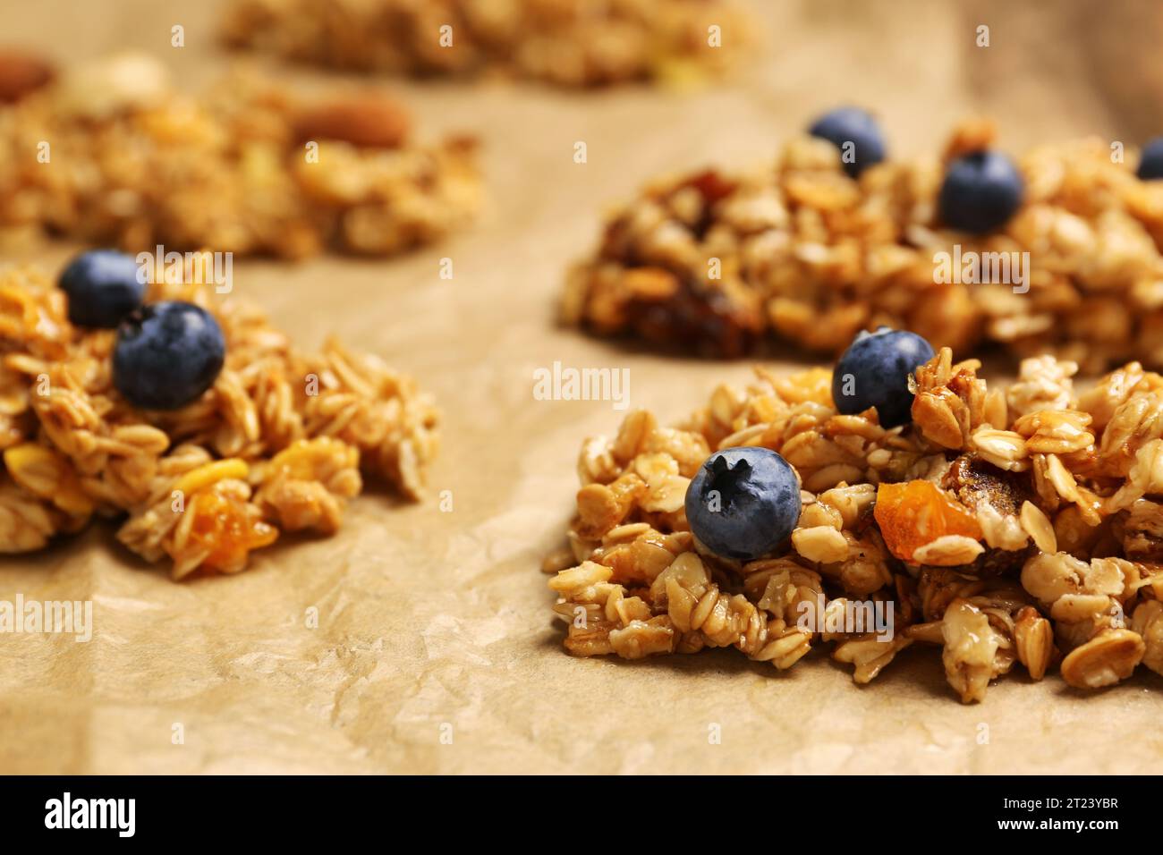 Different granola bars on parchment paper, closeup. Healthy snack Stock ...