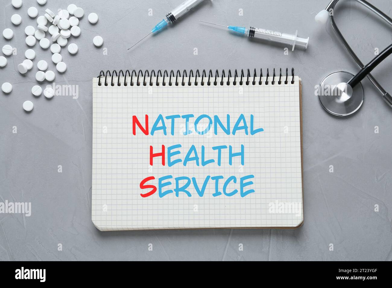 National health service (NHS). Notebook with text, stethoscope, pills ...