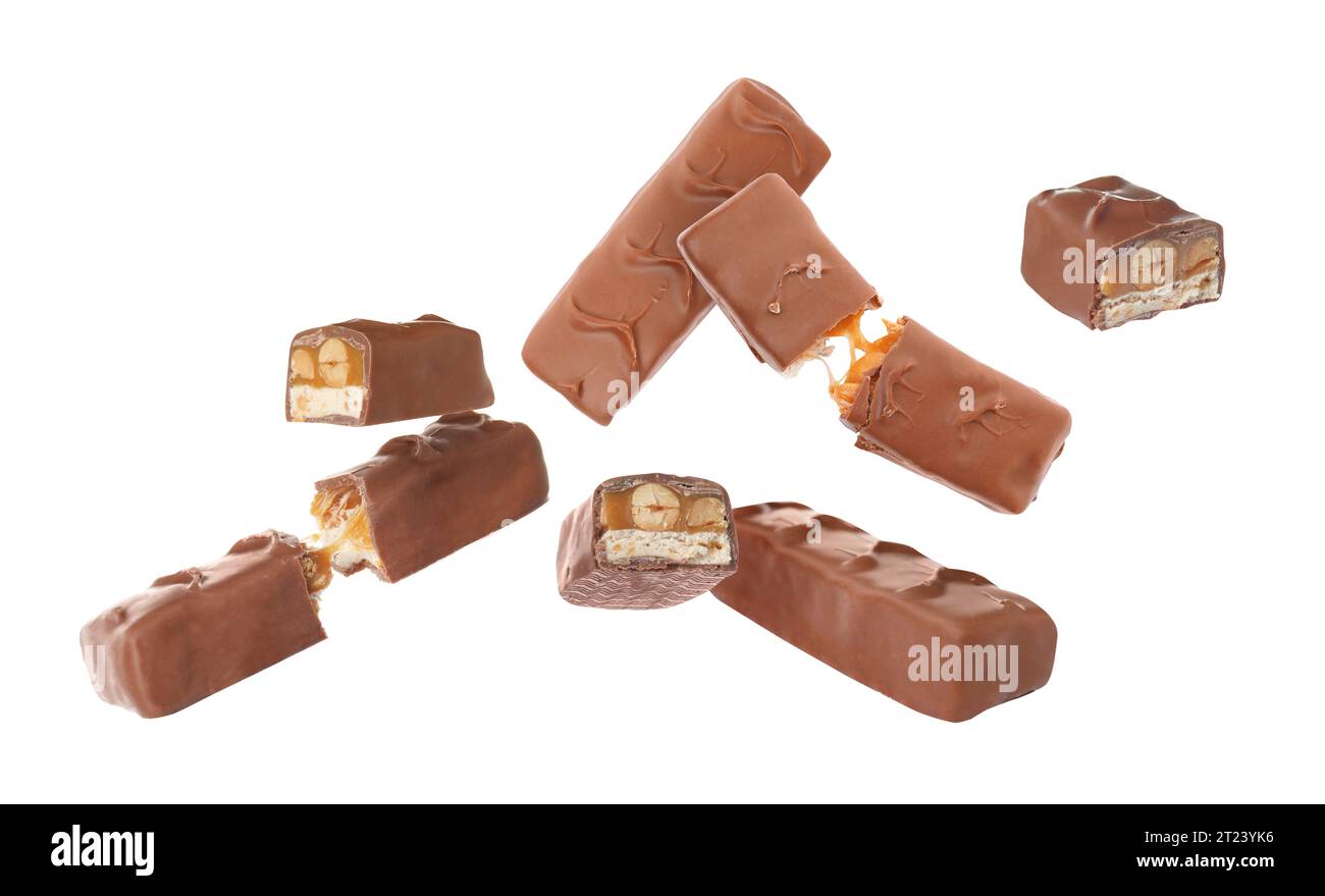 Whole and broken chocolate bars with caramel, nuts and nougat falling ...