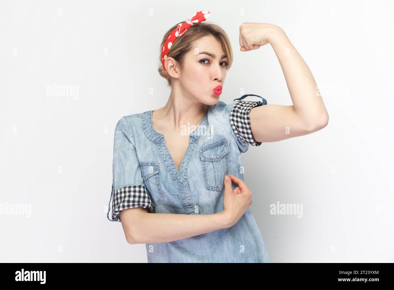 Portrait of strong powerful blonde woman wearing blue denim shirt and ...