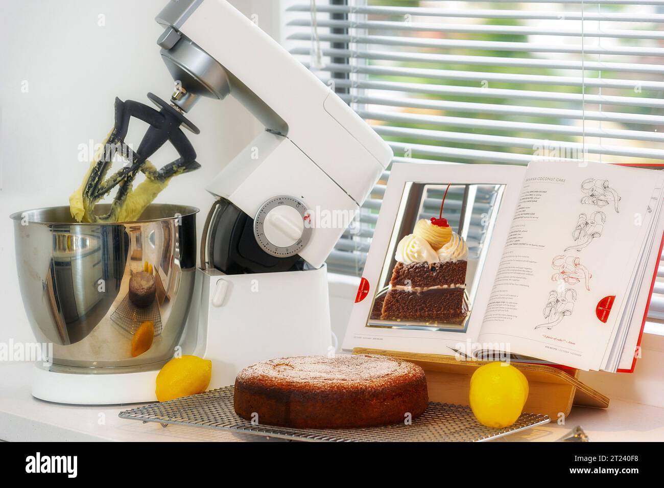 Cake preparation with mixer, recipe book, finished cake and lemons ...