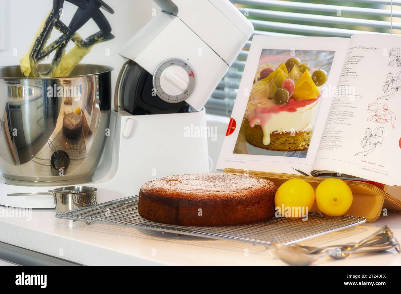 Cake preparation with mixer, recipe book, finished cake and lemons ...