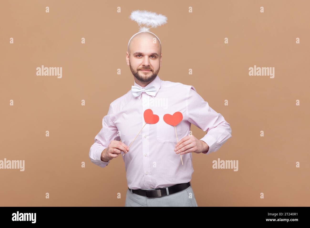Portrait of cute friendly bald bearded man with nimb over head, holding ...