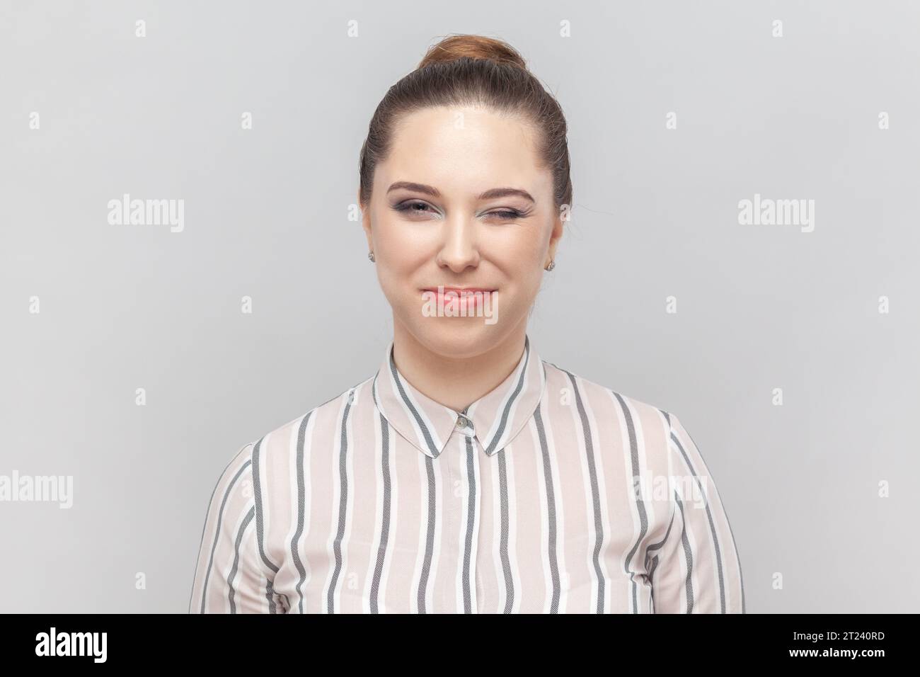 Portrait Of Beautiful Playful Woman Wearing Striped Shirt Standing