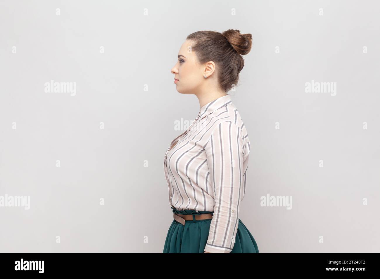 Side view portrait of serious strict woman with bun hairstyle wearing ...