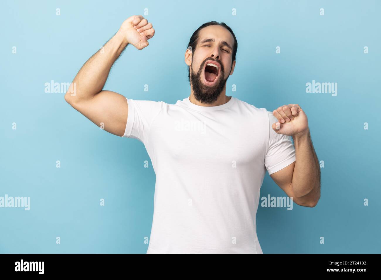 Portrait of sleepy handsome man with beard wearing white T-shirt ...
