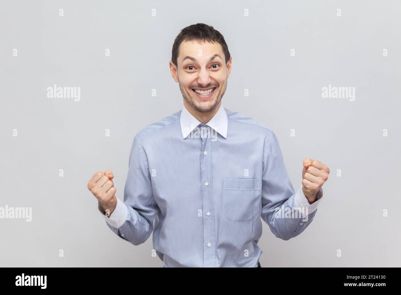 Portrait of extremely happy joyful cheerful man standing with clenched ...