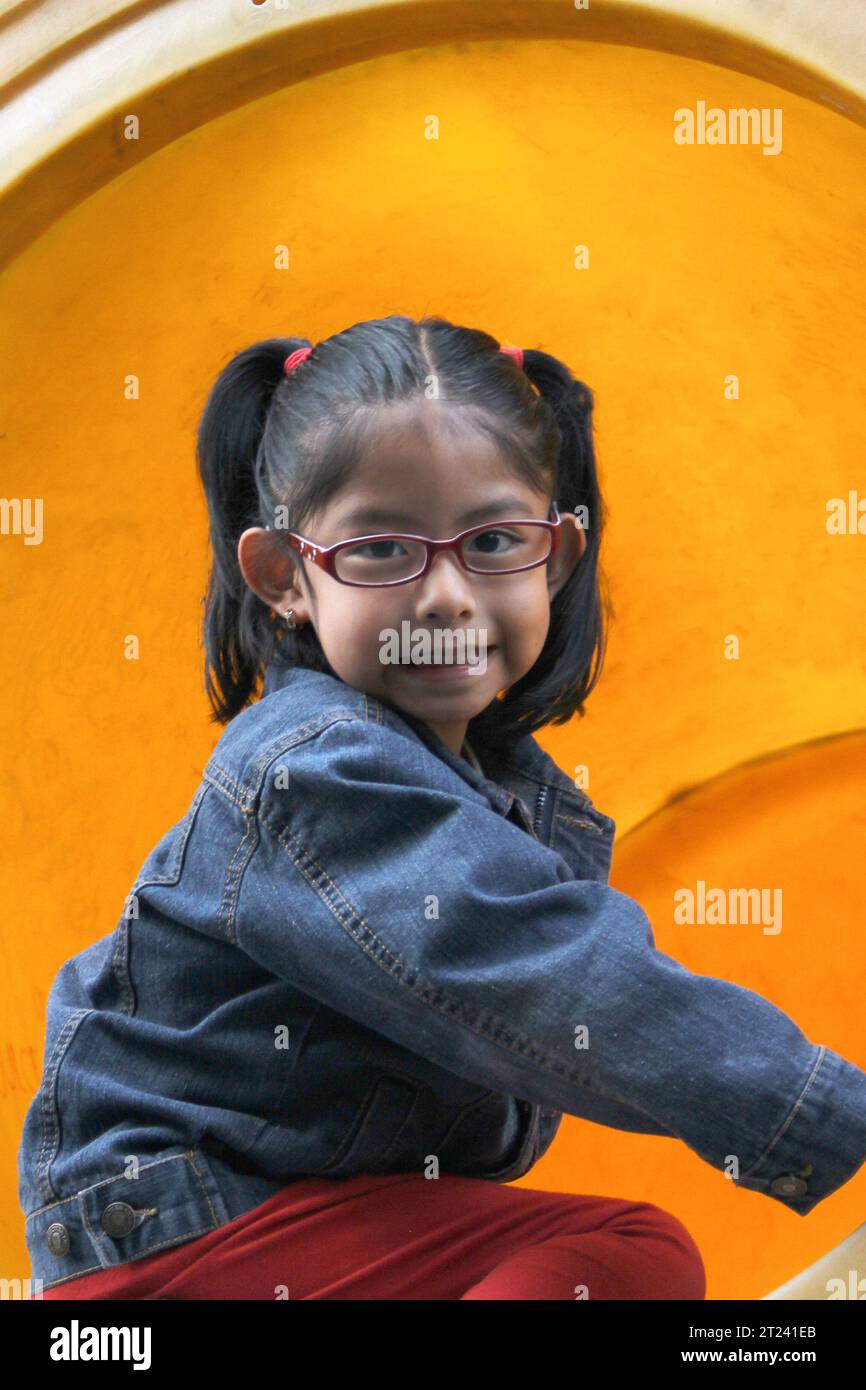 4 year old Latina brunette girl with eye glasses plays in the ...