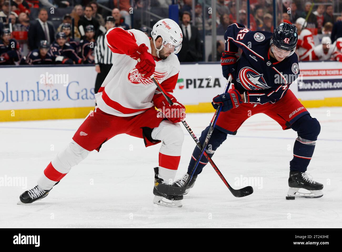 Detroit Red Wings' Jake Walman, left, clears the puck past Columbus ...