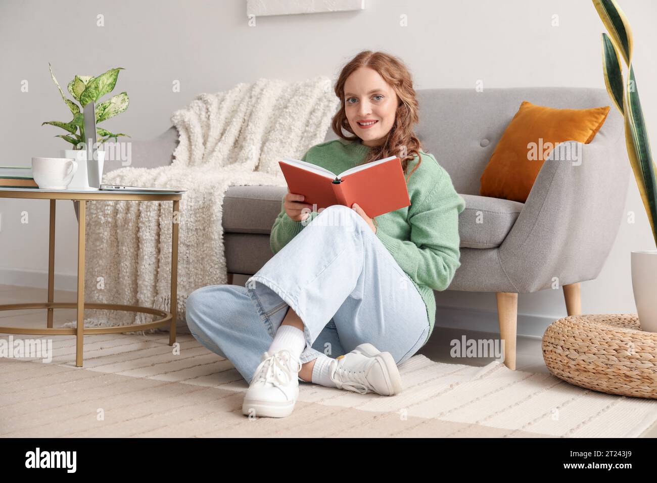 Beautiful redhead woman reading book at home Stock Photo - Alamy