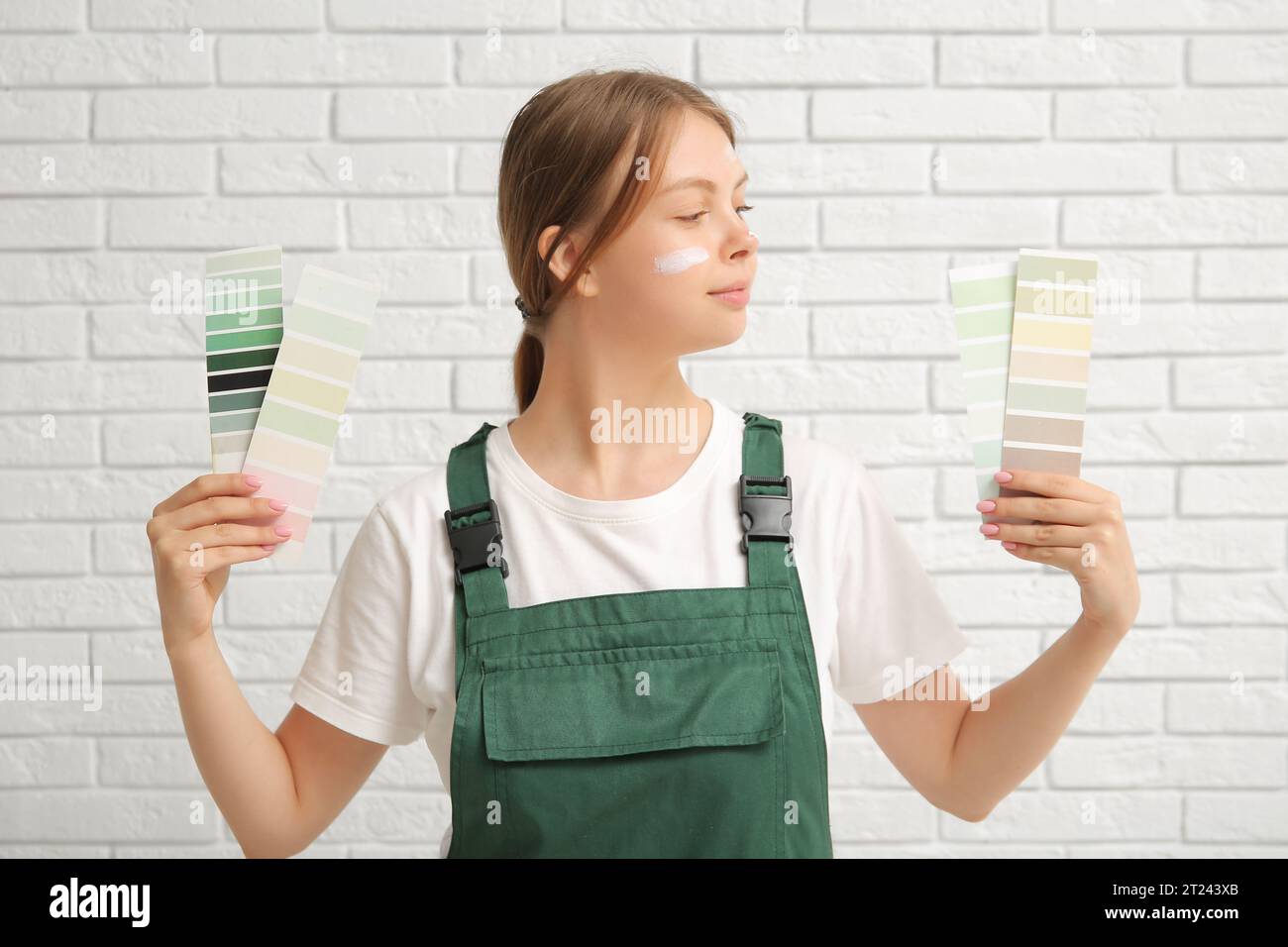 Female decorator with color palettes on white brick background Stock ...