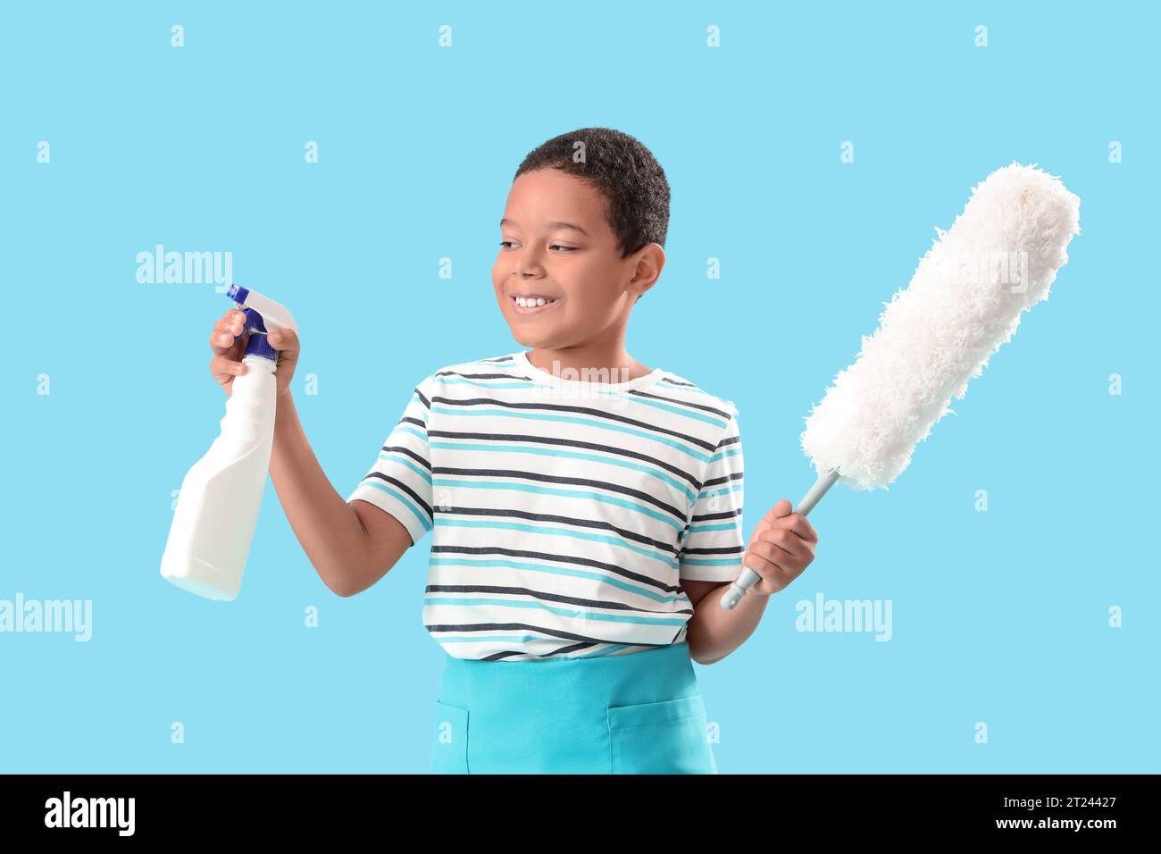 Cute little African-American boy with cleaning supplies on blue ...