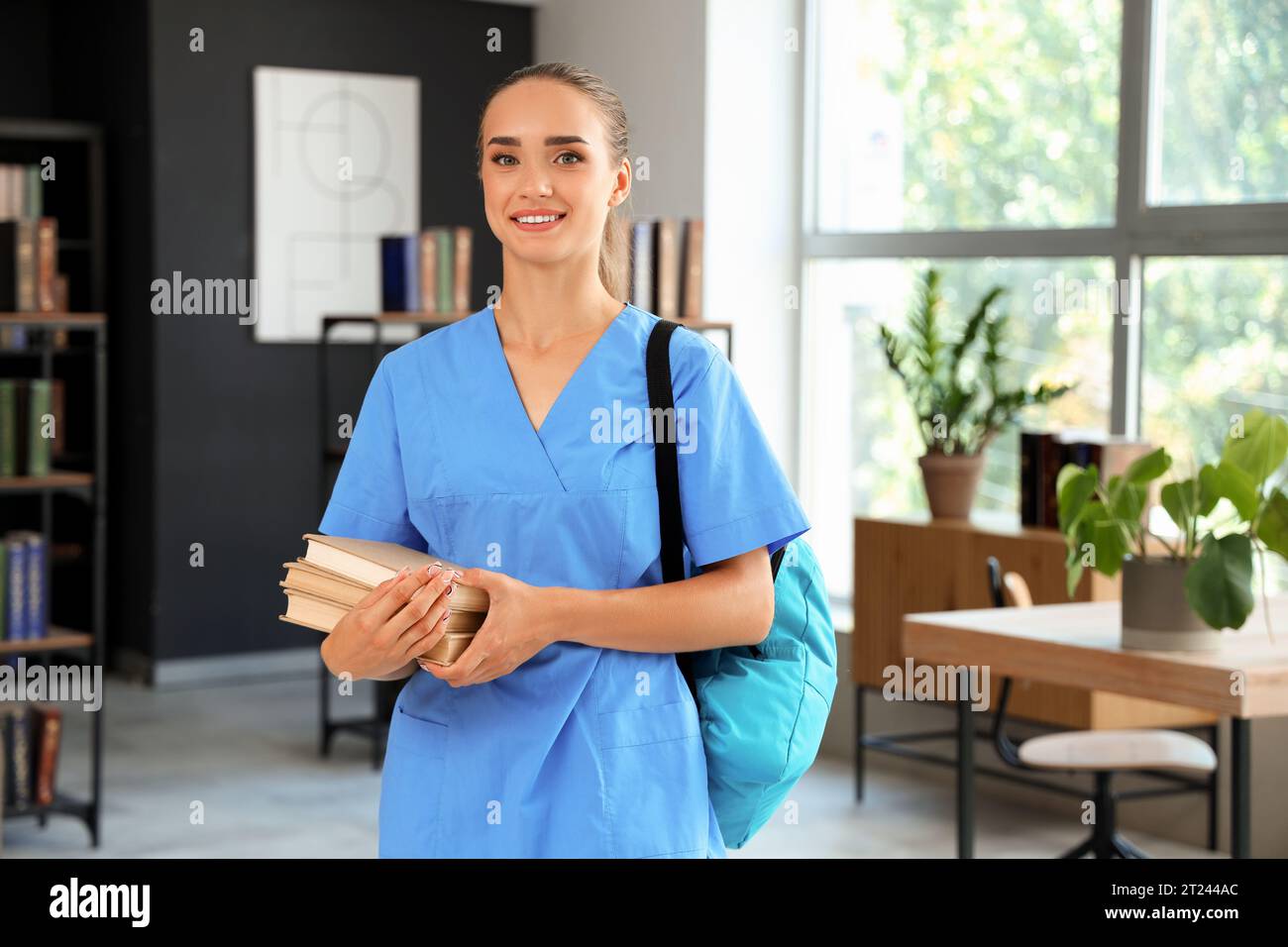 Female medical student with books in library Stock Photo - Alamy