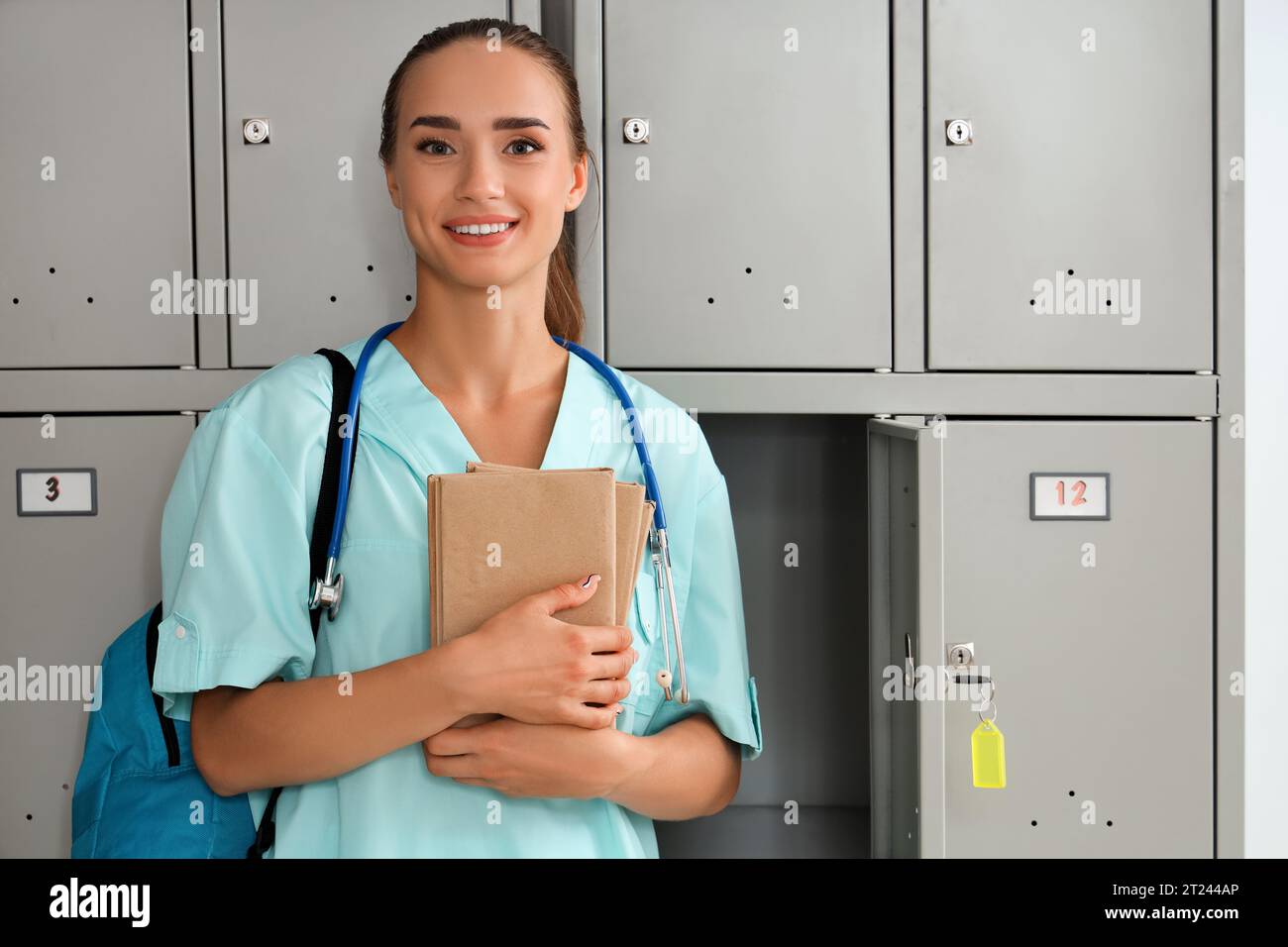 Female medical student with books near locker at university Stock Photo ...