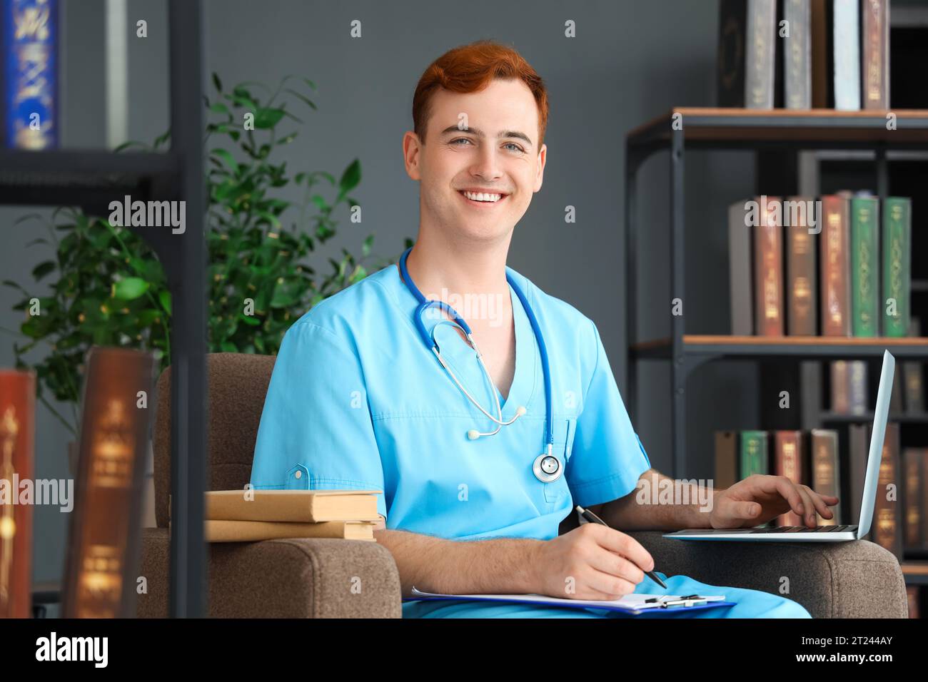 Male medical student studying with laptop in library Stock Photo - Alamy