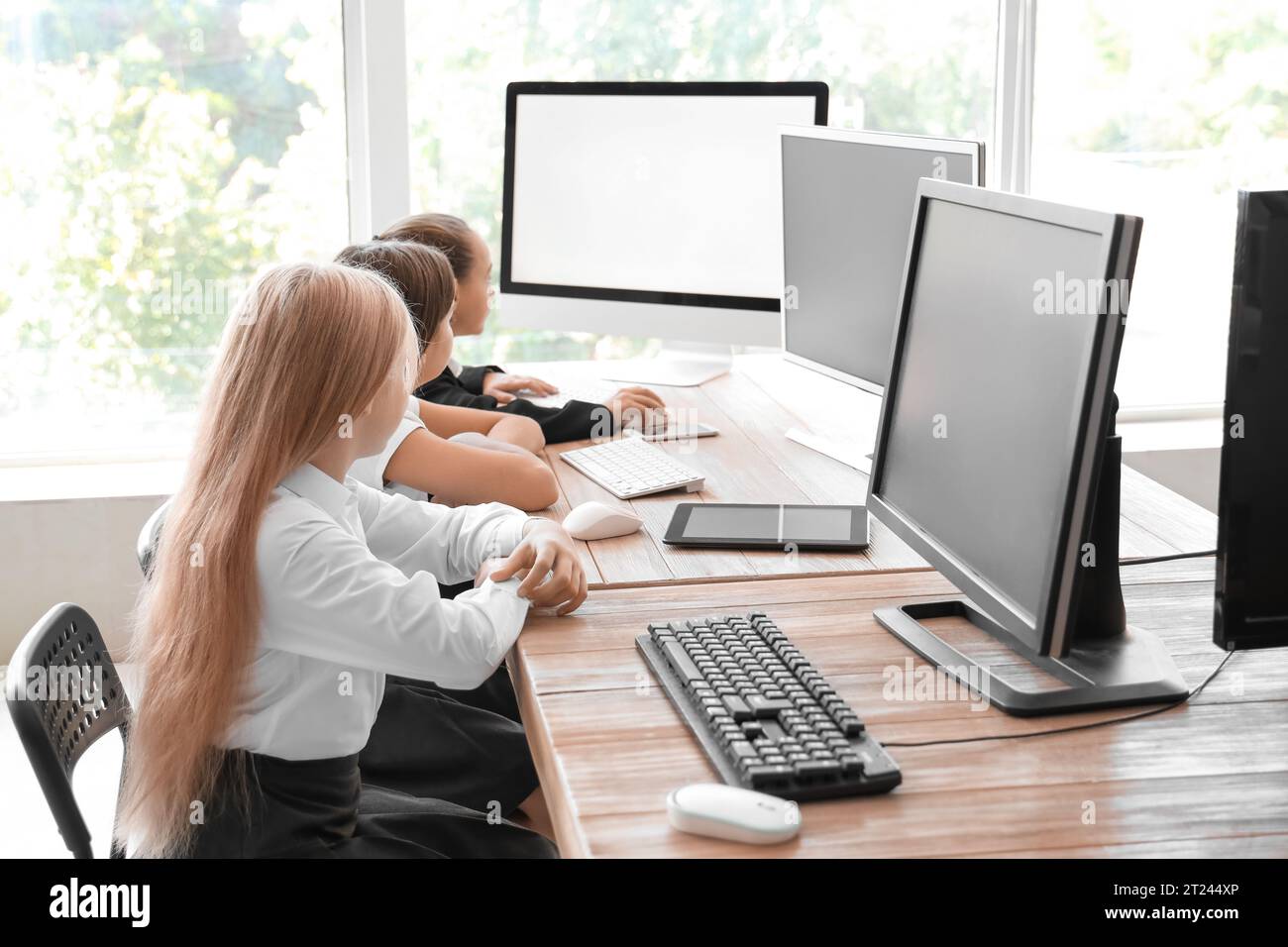 Little girls studying at school computer lab Stock Photo - Alamy