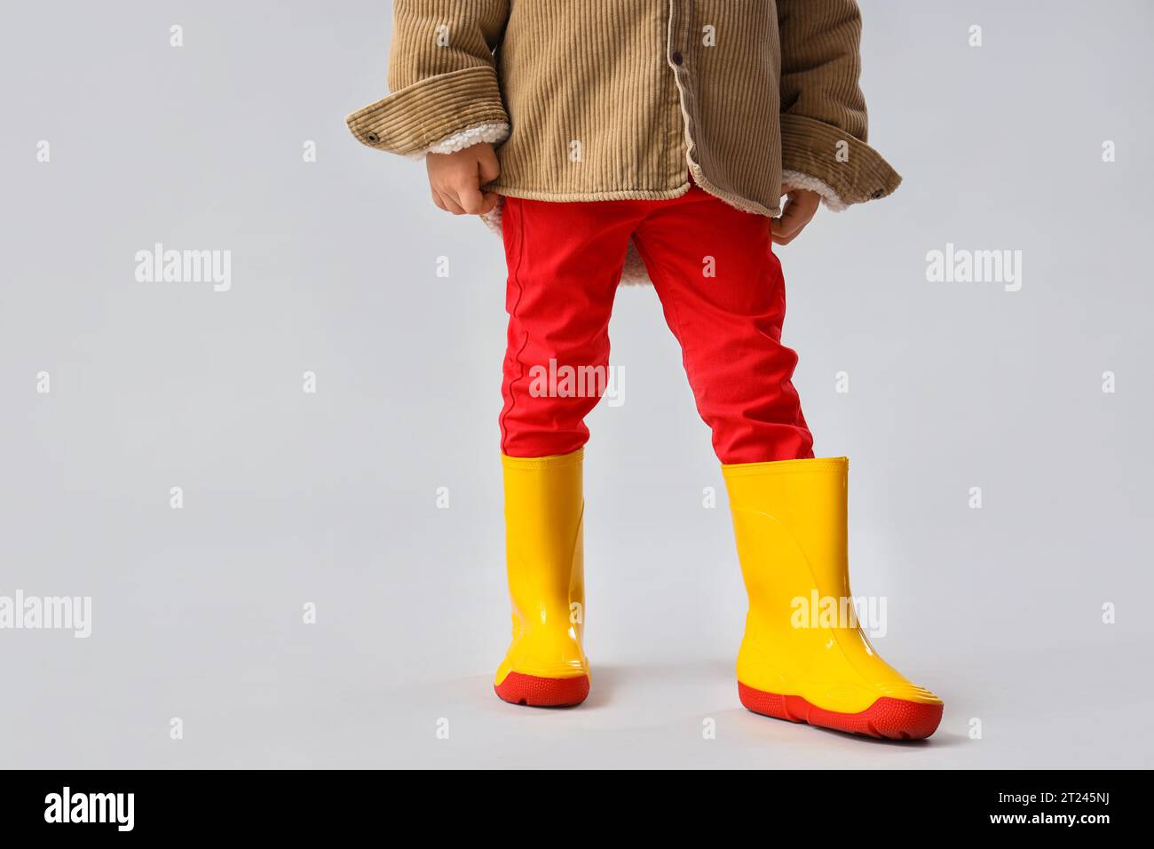 Little boy in rubber boots on light background Stock Photo - Alamy