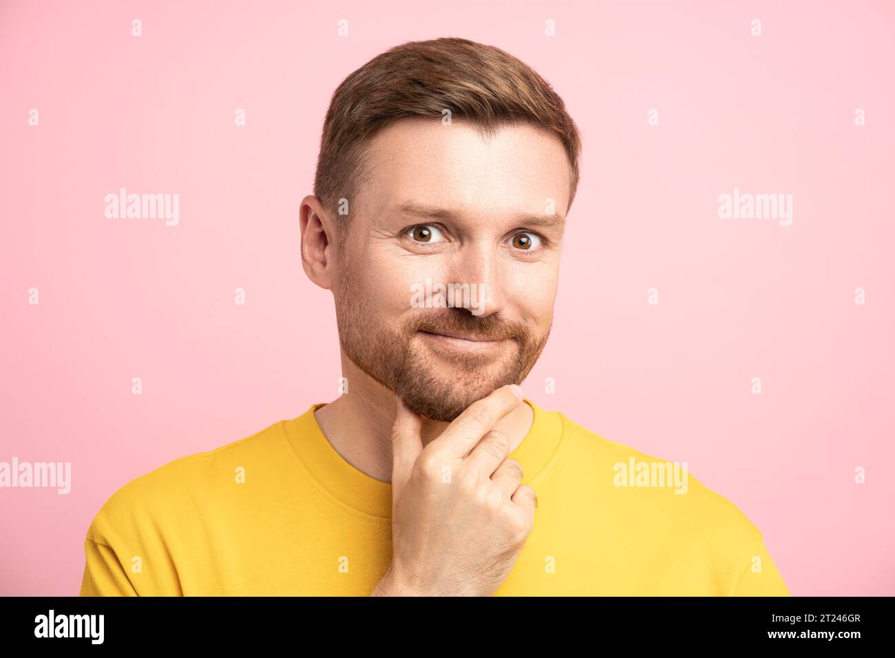 Interested man looks at camera with palm pressed to chin. Portrait ...