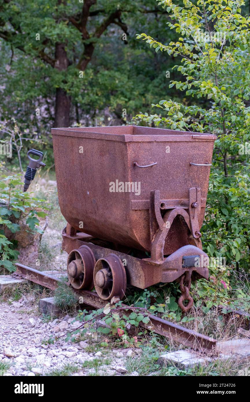 Old rusty mining cart on a rail track . Decoration in the park Stock ...
